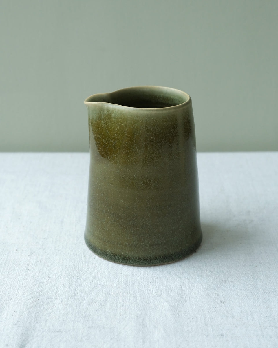 Ceramic milk jug with moss-green glaze, made by Sophia McEvoy – Land Tales