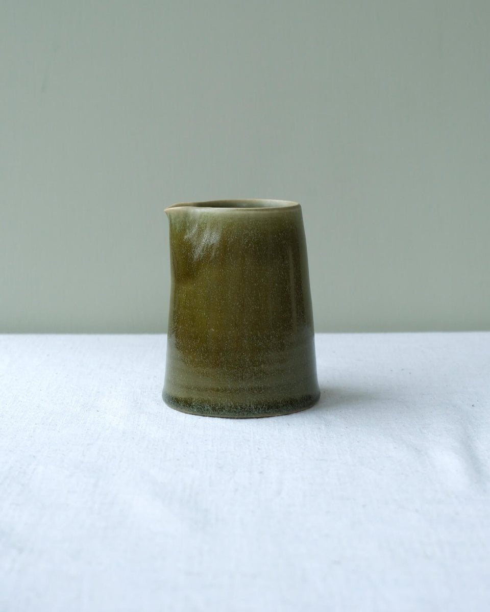 Ceramic milk jug with moss-green glaze, made by Sophia McEvoy – Land Tales